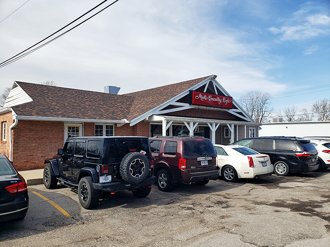 The unassuming exterior of Mel's Country Cafe sits like a red-signed promise of comfort food bliss under Missouri skies.