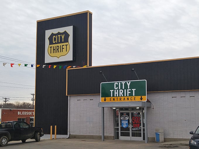 The iconic black and white exterior of City Thrift Waldo stands like a beacon for bargain hunters, complete with festive pennant flags that seem to whisper, "Treasures await inside!"