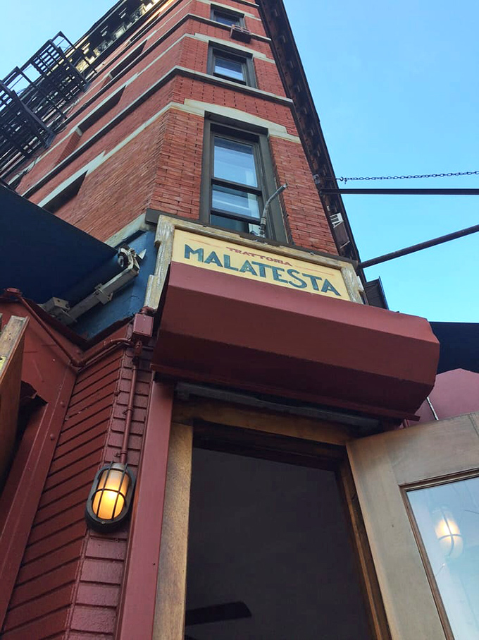 The corner where pasta dreams come true. Malatesta's weathered sign and rustic wooden windows promise authentic Italian comfort without pretension.