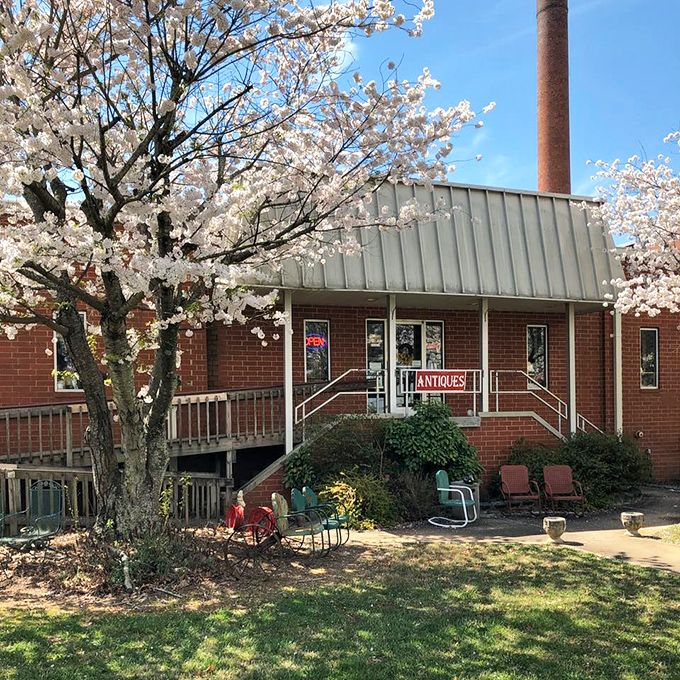 The unassuming brick fa&ccedil;ade with its vintage metal chairs and flamingo sentinel&mdash;proof that the best treasure maps often start with a simple "ANTIQUES" sign.