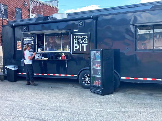 The black food truck of destiny stands ready, its "RAY RAY'S HOG PIT" sign a beacon to barbecue pilgrims seeking smoky salvation in Columbus.
