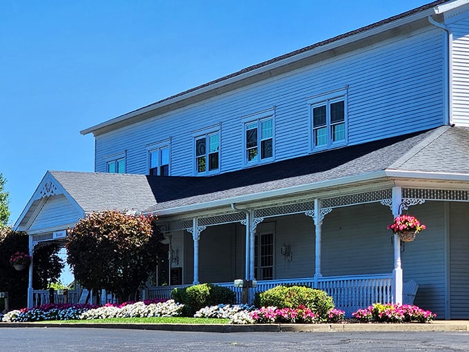 The classic white clapboard exterior of Amish Door Restaurant stands like a welcoming beacon, complete with wraparound porch and vibrant flower beds that change with Ohio's seasons.