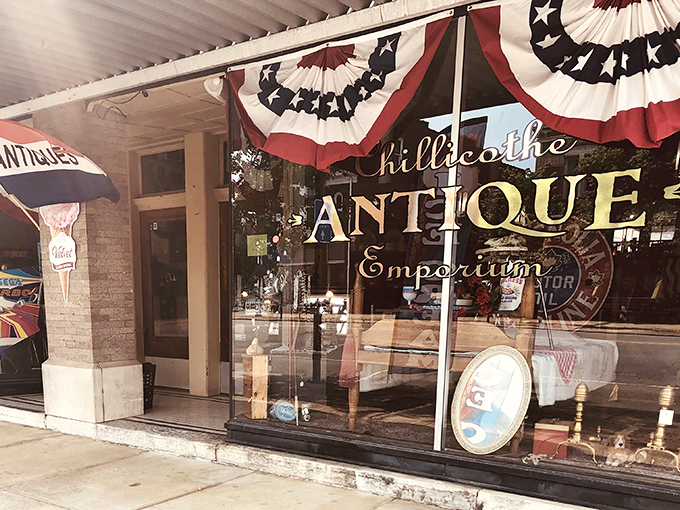 The storefront beckons like a time portal, with mid-century furniture artfully arranged behind glass and that glowing "Chillicothe ANTIQUE" sign promising adventures in nostalgia.