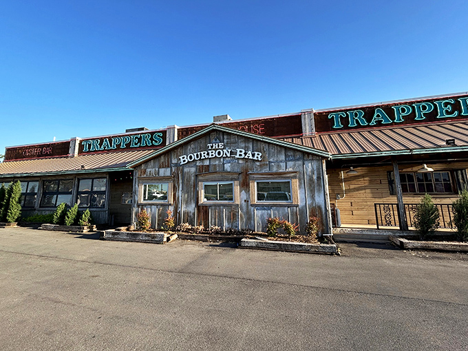 The rustic wooden facade of Trapper's beckons like an old friend, promising comfort food with Cajun flair beneath those neon signs.