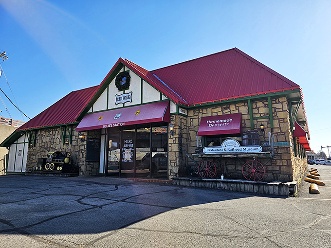 The stone exterior of Ollie's Station Restaurant stands like a welcoming depot, complete with vintage railway wagon and distinctive red roof that signals culinary adventures ahead.