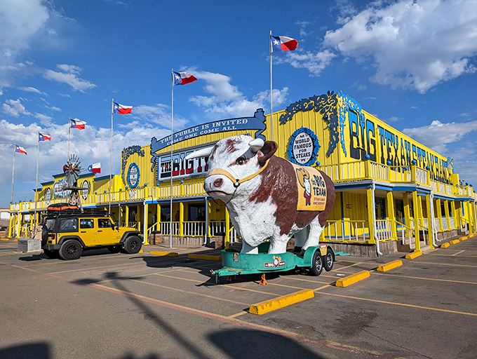 The bright yellow facade of The Big Texan stands like a neon beacon in the Texas Panhandle, complete with a cow statue that's dressed better than most tourists.