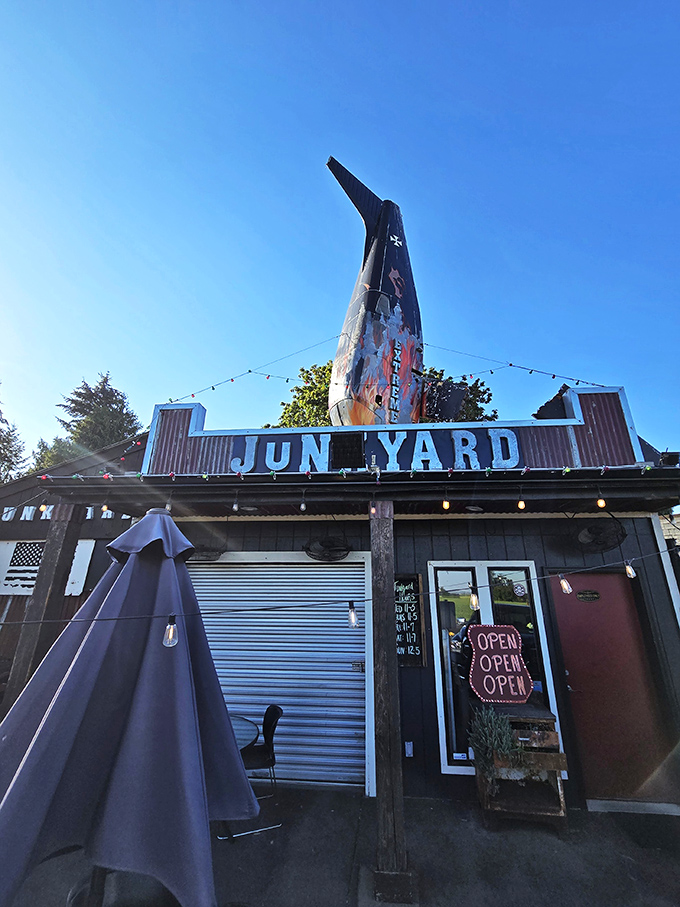 Not your average roadside stop! Junkyard's distinctive fin-shaped sign beckons hungry travelers like a burger lighthouse guiding ships to delicious shores.