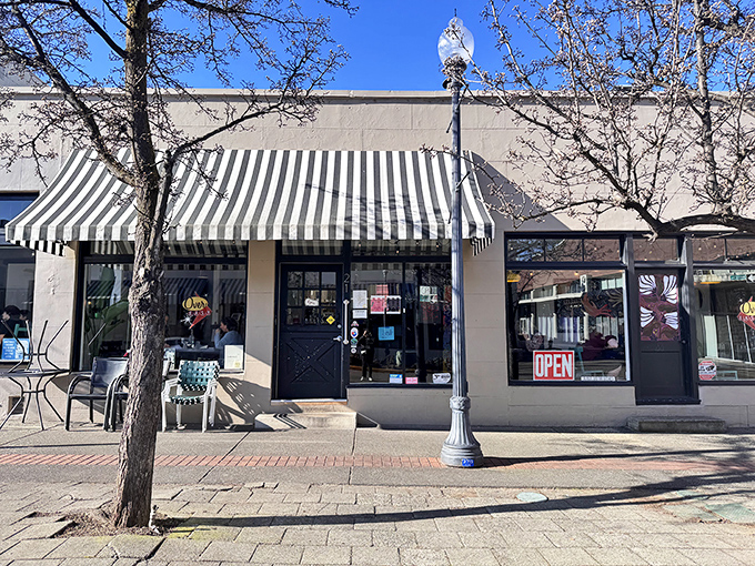 The storefront beckons with its simple charm&mdash;black door, striped awning, and outdoor seating that whispers, "Come in, the eggs are waiting." 