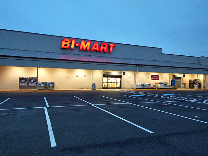 The iconic red Bi-Mart sign against a blue Oregon sky promises treasure hunting adventures within. Garden plants stand ready for your next backyard project.