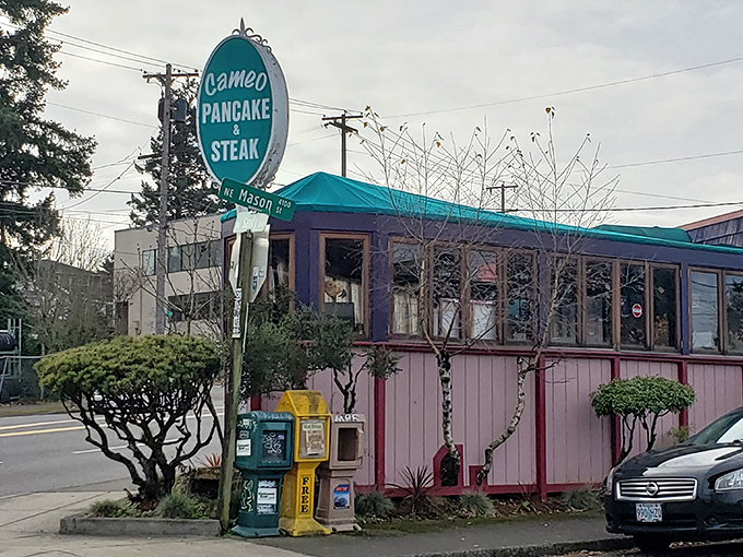 The welcoming teal awning and pink exterior of Cameo Cafe East beckons like a colorful promise of breakfast bliss in Portland's morning landscape. 