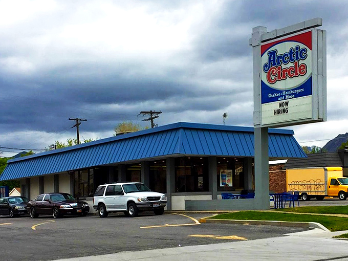 The iconic blue roof of Arctic Circle stands like a beacon of comfort food against the Utah sky, promising fry sauce nirvana within.