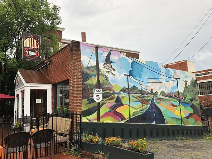 The unassuming brick exterior of Millie's Diner belies the culinary magic happening inside. That colorful mural isn't just decoration&mdash;it's a preview of the vibrant flavors awaiting you.