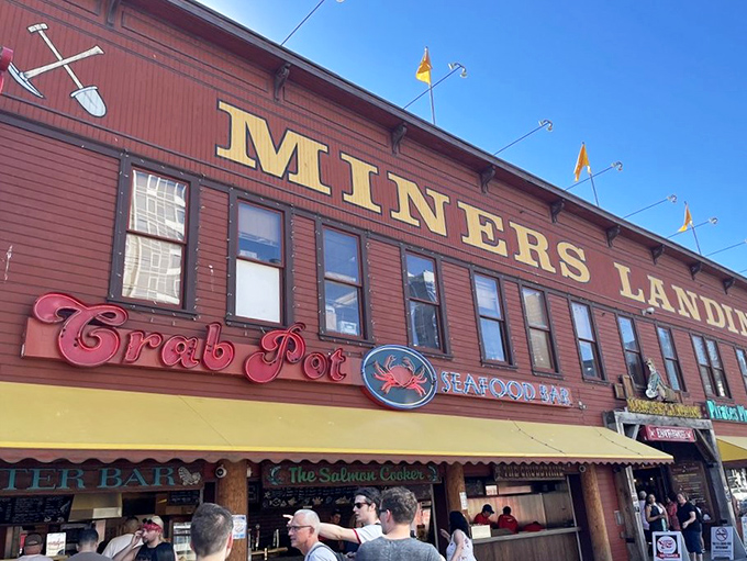The iconic red crab sign beckons seafood lovers like a crustacean lighthouse on Seattle's waterfront, promising maritime delights within the rustic wooden building.