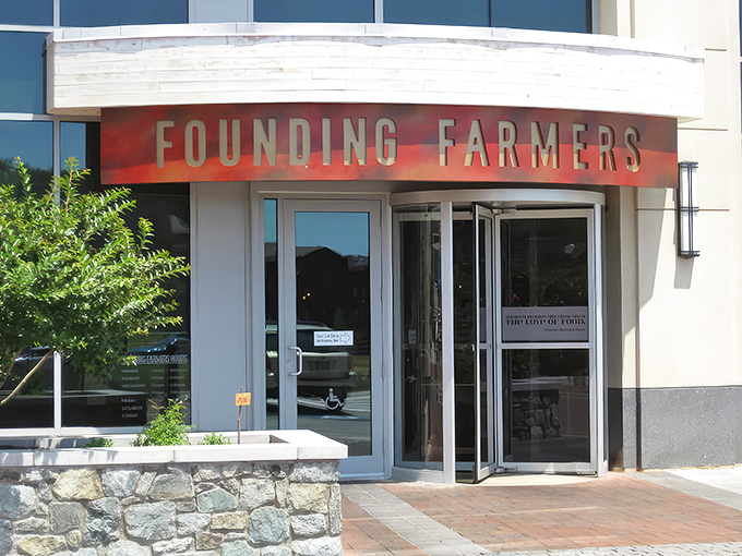 The curved awning and bold red lettering of Founding Farmers beckons like a culinary lighthouse in Potomac's upscale landscape. Farm-to-table paradise awaits.