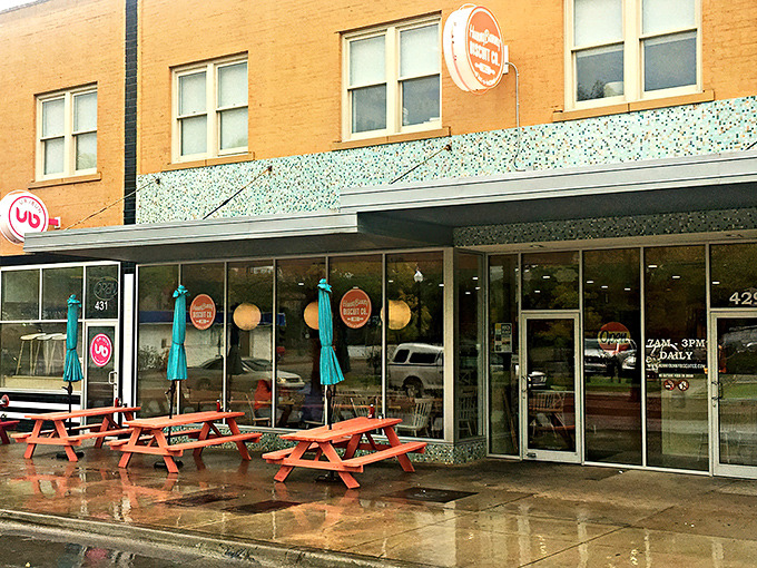 The coral-railed patio at HunnyBunny beckons like a breakfast siren song, with the iconic Tower Theater sign standing guard nearby.