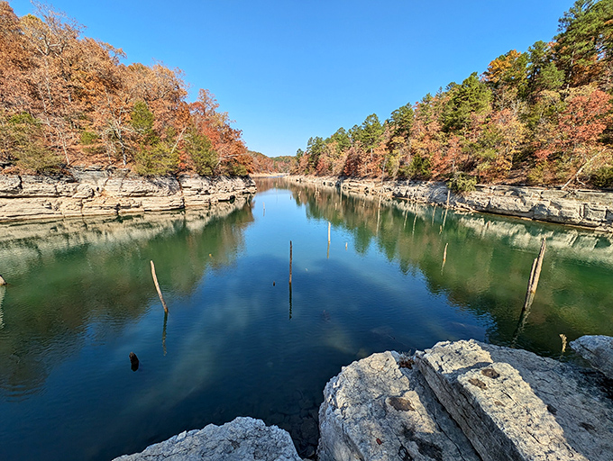 Nature's mirror game is unbeatable here, where autumn-painted limestone bluffs create perfect reflections in waters so clear you'll question which way is up.