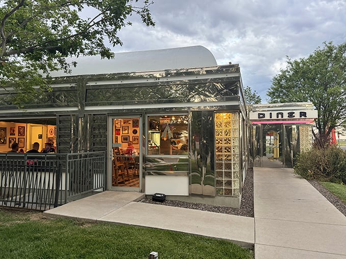 That neon sign doesn't whisper&mdash;it announces with retro swagger: "Hungry humans, your comfort food paradise awaits!" The turquoise and red color scheme practically sings against the Colorado sky.