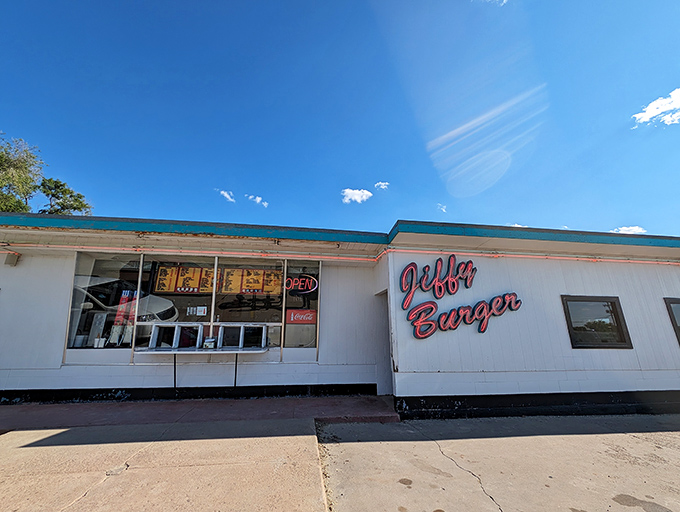 The unassuming exterior of Jiffy Burger stands like a time capsule under the Kansas sky, its vintage sign promising simple pleasures that never go out of style.