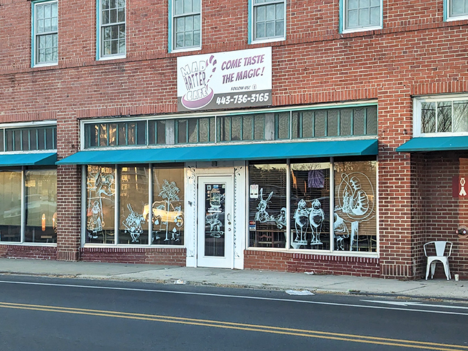 The brick facade of Mad Hatter Cafe beckons with whimsical window art and a turquoise awning&mdash;Lewis Carroll's fantasy brought to life on Salisbury's Main Street.