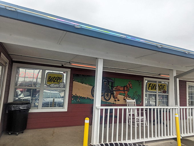 The unassuming burgundy exterior with its "Try our Amish Butter and Cheeses" sign promises treasures within that the simple facade modestly conceals. 