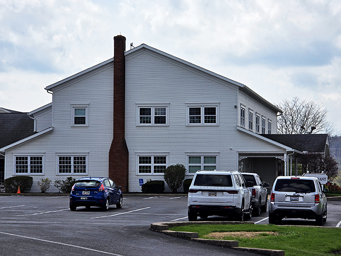 The classic white clapboard exterior of Amish Door Restaurant stands like a welcoming beacon, complete with wraparound porch and vibrant flower beds that change with Ohio's seasons.