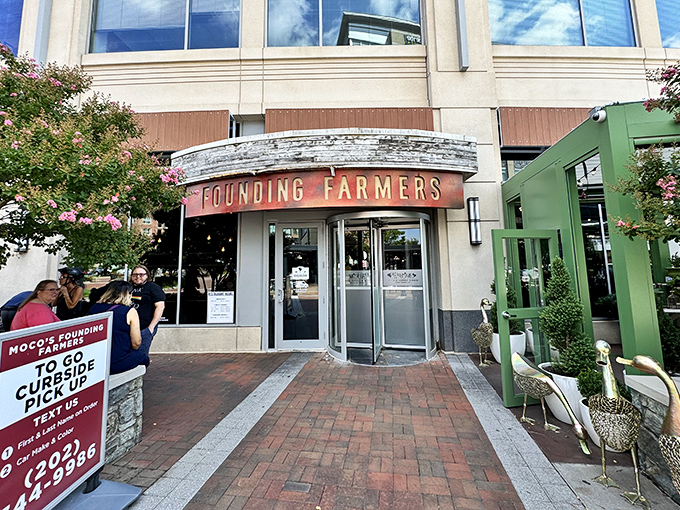 The curved awning and bold red lettering of Founding Farmers beckons like a culinary lighthouse in Potomac's upscale landscape. Farm-to-table paradise awaits.