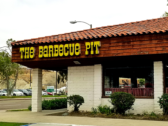 The unassuming exterior of The Barbecue Pit stands like a beacon of hope for hungry travelers. That yellow sign promises smoky salvation within those humble walls.