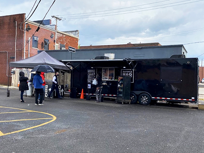 The black food truck of destiny stands ready, its "RAY RAY'S HOG PIT" sign a beacon to barbecue pilgrims seeking smoky salvation in Columbus.