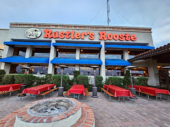 The welcoming facade of Rustler's Rooste stands proud against the Arizona sky, where blue awnings and red tablecloths hint at the Western hospitality waiting inside.
