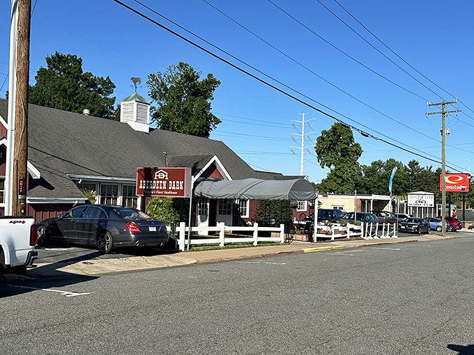 The iconic red barn exterior of Aberdeen Barn stands proudly on Holiday Drive, welcoming hungry patrons with its charming white picket fence and unmistakable rustic appeal.
