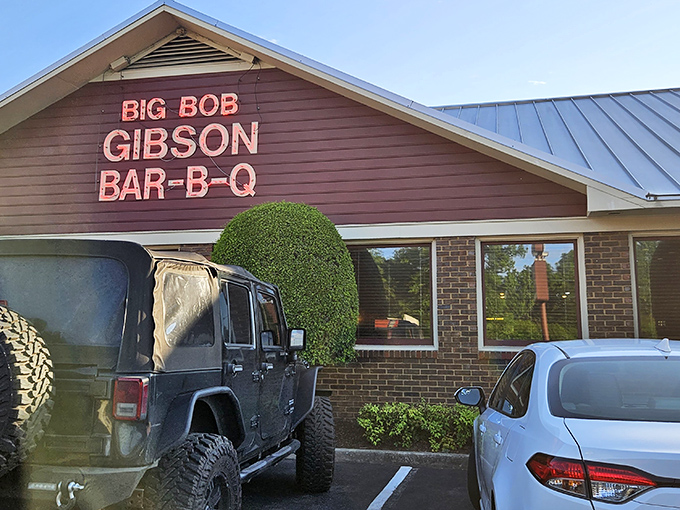 The neon sign glows like a barbecue beacon, promising smoky salvation to hungry travelers. Big Bob Gibson's exterior says it all: serious barbecue happens here.