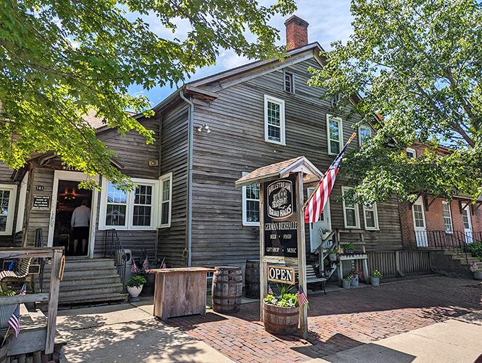 The weathered wooden exterior of Millstream Brau Haus stands like a time capsule from old-world Germany, miraculously transported to the Iowa countryside.