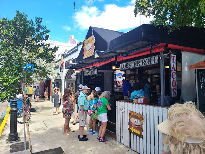 The white picket fence isn't keeping anyone out—it's corralling hungry seafood lovers into this Key West treasure where lobster rolls and happiness await.