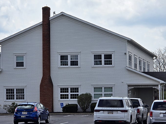 The classic white clapboard exterior of Amish Door Restaurant stands like a beacon of comfort food promise against Ohio's big sky.