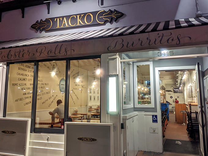 The iconic Tacko storefront proudly announces its dual culinary citizenship with "Tacos," "Lobster Rolls," and "Burritos" emblazoned on its cheerful awning.