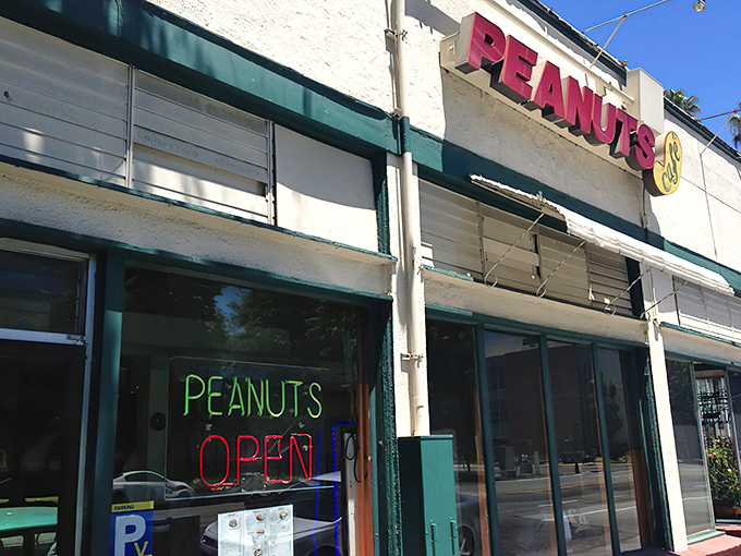 The unassuming white exterior of Peanuts Deluxe Cafe stands like a culinary lighthouse in San Jose, beckoning hungry locals with its bright red signage.