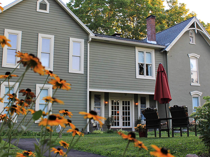 The sage-green farmhouse welcomes you with a porch that practically whispers, "Put down your phone and grab a rocking chair."