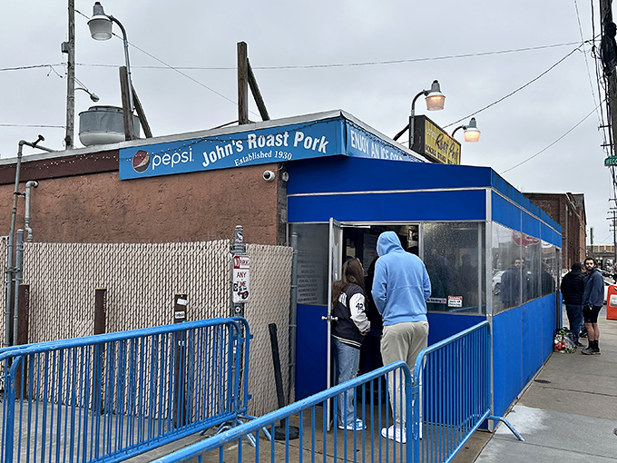 The iconic blue exterior with its cheerful pig mascot stands as a beacon of sandwich excellence in South Philly's industrial landscape.