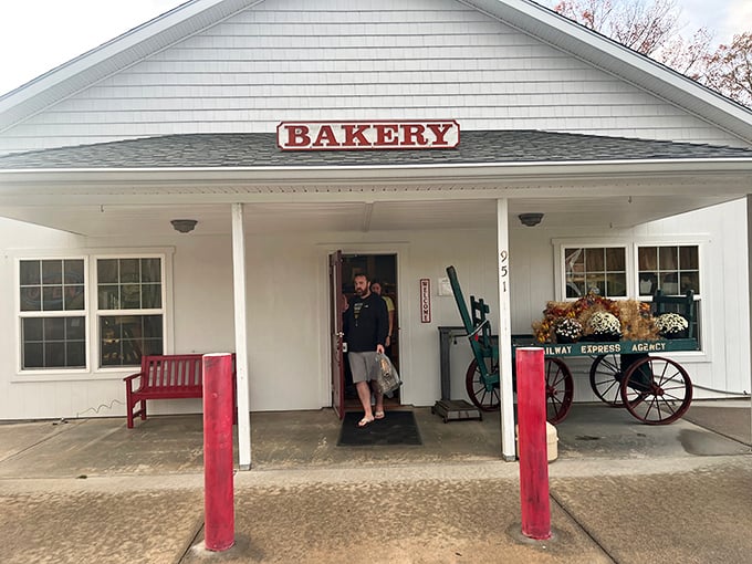 The quintessential country bakery facade&mdash;white clapboard, red accents, and a wooden wagon that silently promises carbs worth every mile of your journey.
