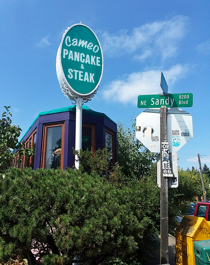 The welcoming teal awning and pink exterior of Cameo Cafe East beckons like a colorful promise of breakfast bliss in Portland's morning landscape. 