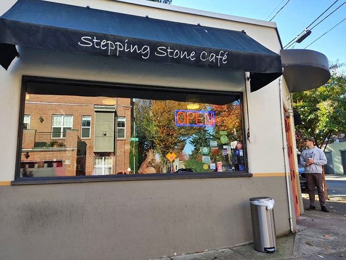 The unassuming storefront of Stepping Stone Caf&eacute;, with its simple black awning and neon "OPEN" sign, promises zero pretension and maximum flavor.