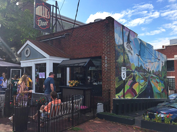 The unassuming brick exterior of Millie's Diner belies the culinary magic happening inside. That colorful mural isn't just decoration&mdash;it's a preview of the vibrant flavors awaiting you.