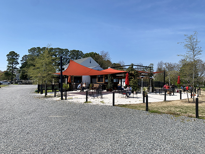 Merroir's unassuming exterior belies the culinary magic within. Those orange umbrellas aren't just for shade&mdash;they're beacons guiding seafood pilgrims to paradise.