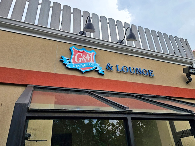 The iconic blue and red G&M sign welcomes seafood pilgrims like a maritime lighthouse, guiding hungry travelers to crab cake nirvana.