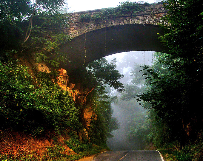 The stone archway of Helen's Bridge emerges from the mist like a portal to another time. Mother Nature's own special effects department working overtime here.
