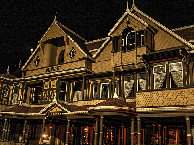 The Winchester Mystery House looms against the night sky, its Victorian façade hiding countless architectural oddities that would make Escher scratch his head in confusion.