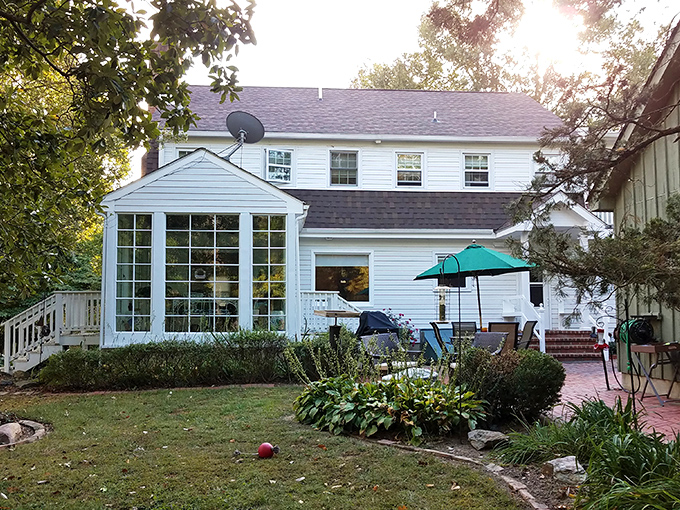 The Miller-Dunham House stands like a Norman Rockwell painting come to life, complete with sunlight filtering through mature trees and a welcoming brick patio.
