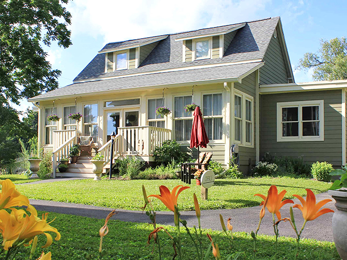 The sage-green farmhouse welcomes you with a porch that practically whispers, "Put down your phone and grab a rocking chair."