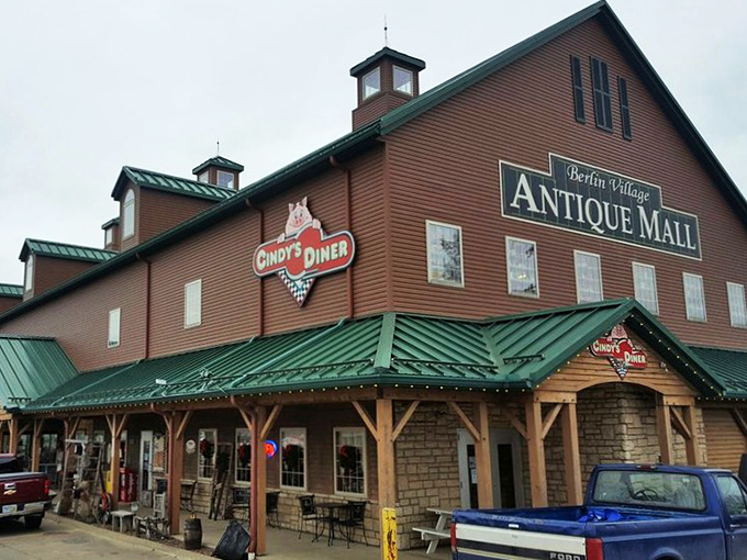 The rustic exterior of Berlin Village Antique Mall stands like a time portal in Ohio's Amish Country, promising treasures within its weathered wooden walls.