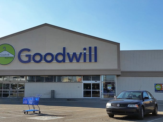 The blue and green branded exterior of Goodwill beckons like a treasure map's final destination—adventure awaits just beyond those sliding glass doors.